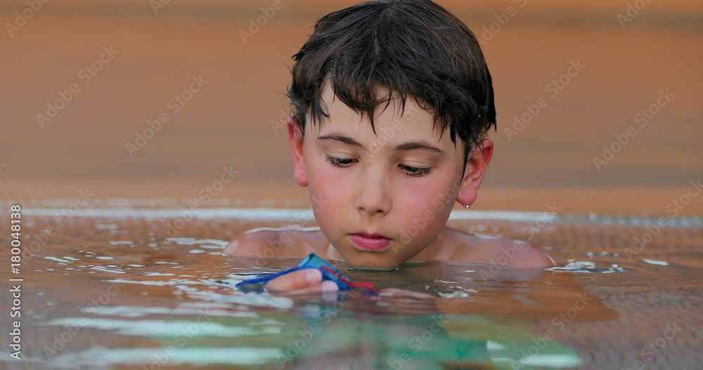 Contemplative child playing by himself at the swimming pool in 60fps 4k ...