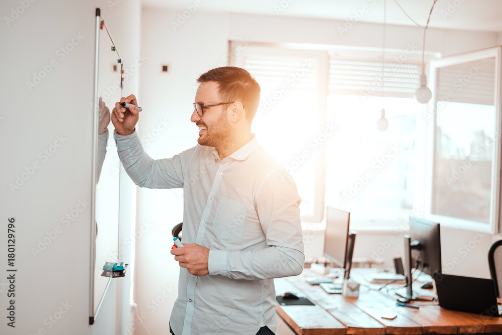 Planning is a key to success. Confident young man sketching on ...