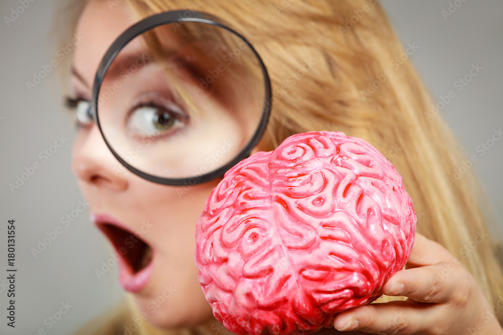 Woman holding magnifying glass investigating brain Stock Photo | Adobe ...