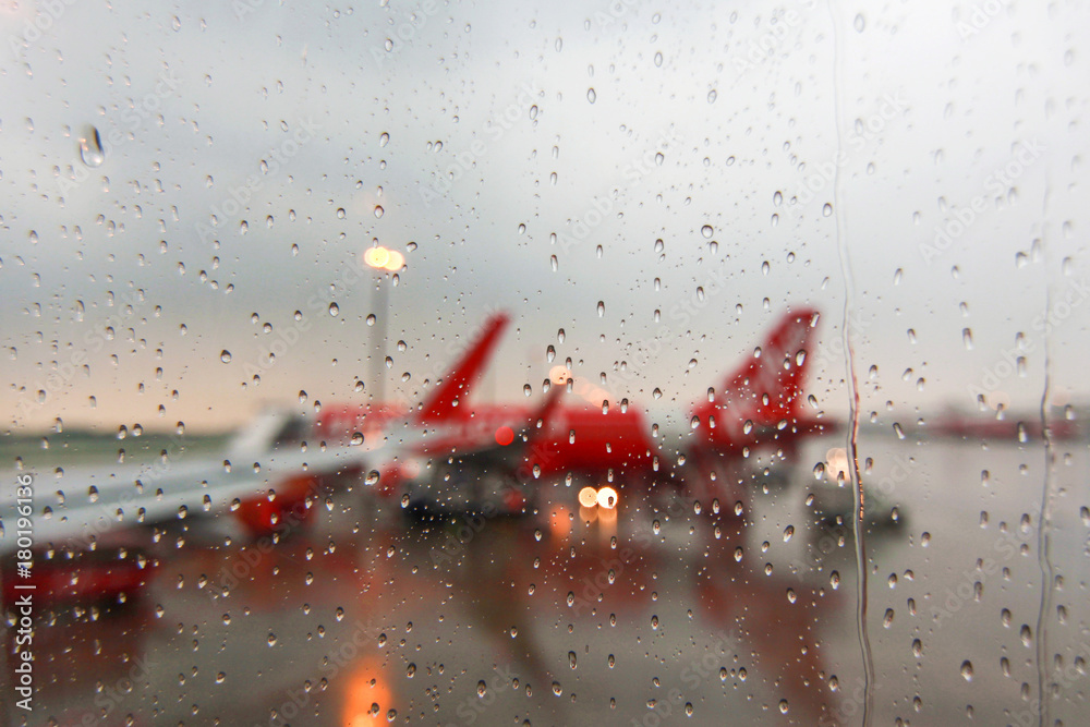 Rain drop on airplane window with blur wing and airplane background at ...