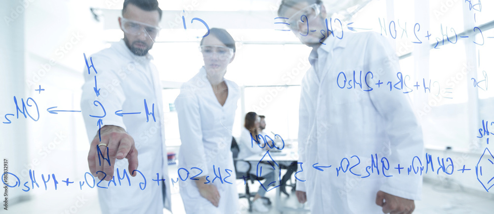 group of laboratory scientists discussing their research in the ...