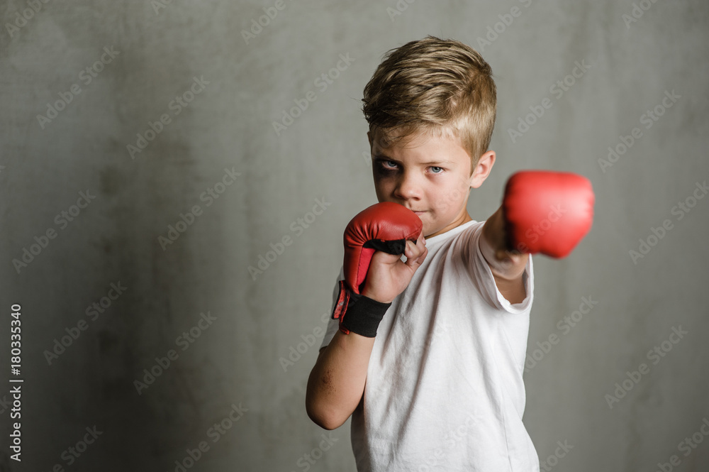 Beaten young boy punching with red boxing gloves. Space for text Stock ...
