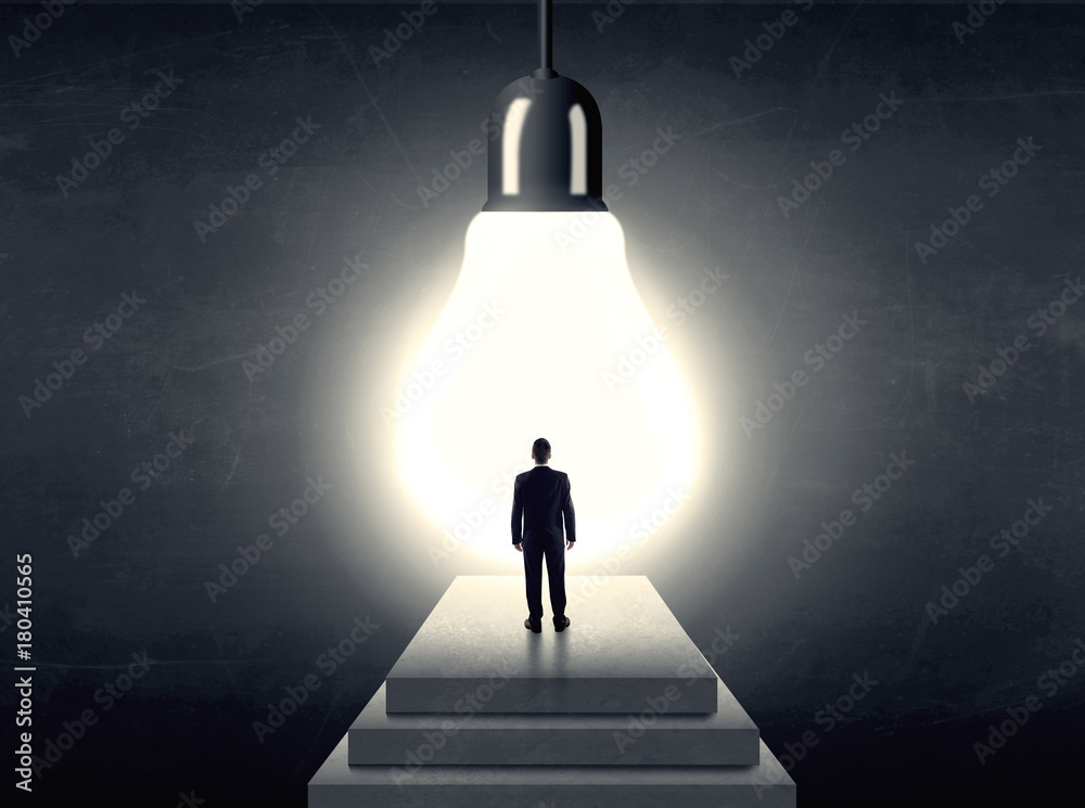 Man standing on a step in front of a huge light bulb Stock Photo ...