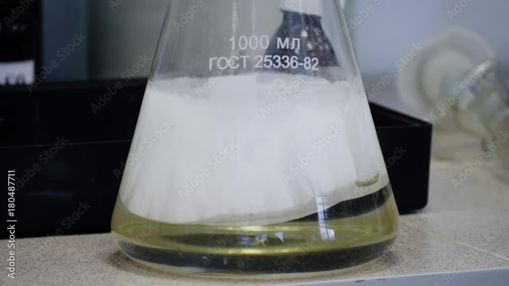 Laboratory glass Erlenmeyer conical flask filled with chemical white ...