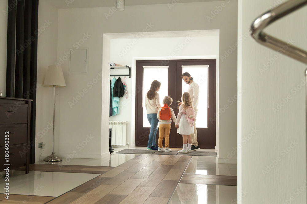 Happy family going out standing in hallway opening door, parents ...