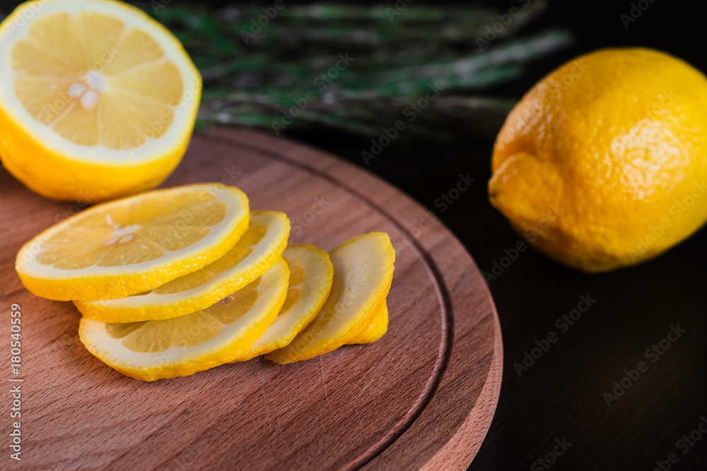 Yellow lemon cut into round slices on a wooden Board and a sprig of ...