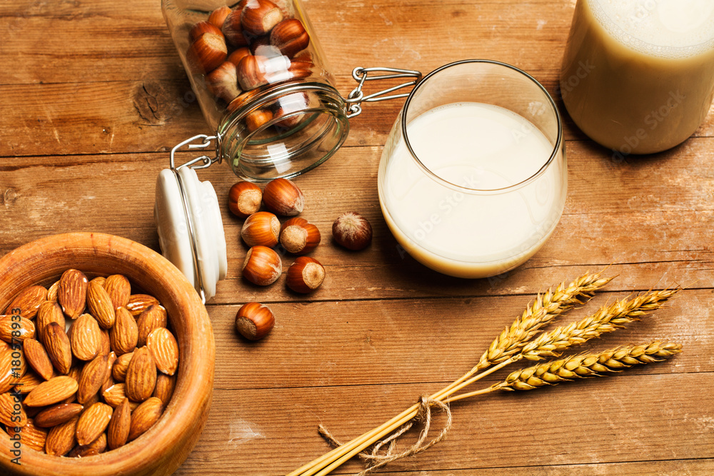 Vaso con leche natural y fresca junto a frutos secos sobre un fondo de ...