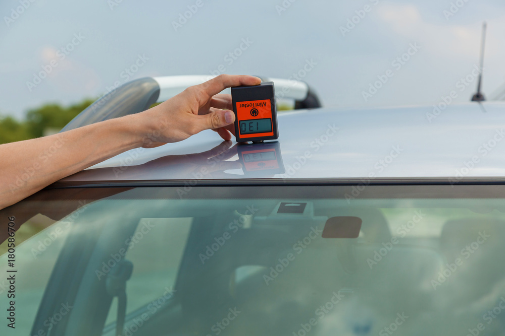 Checking the body roof of the car, the man measures the car's body, the ...