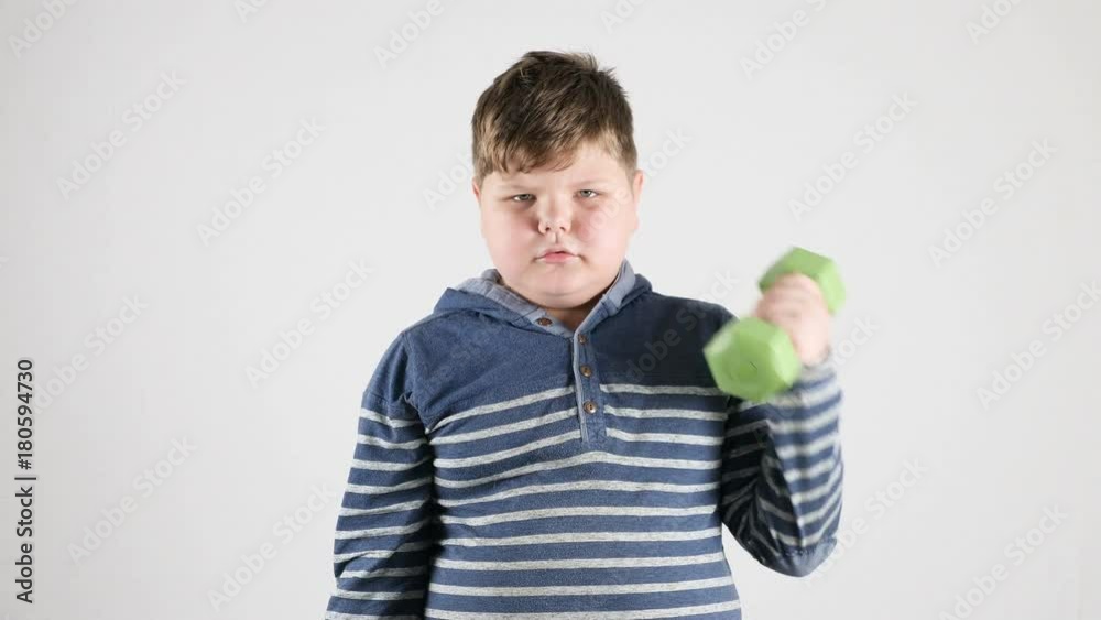 Young fat boy does the exercise with dumbbells pumps the biceps 50 fps ...