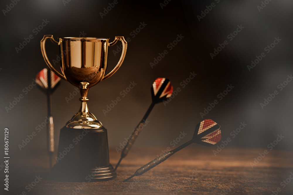red three darts arrows in the target center with golden trophy victory ...