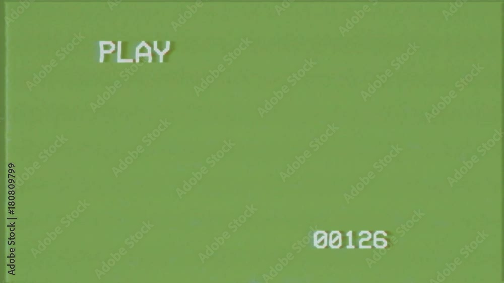 An old bad VHS tape playing. Green screen with PLAY text only. A ...