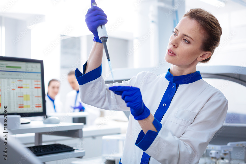 Blood test. Experienced appealing female laboratorian measuring liquid ...