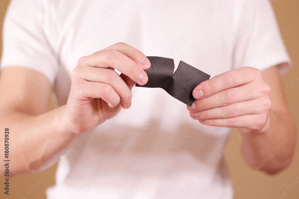 Man tearing a piece of paper in half blank black flyer brochure booklet ...