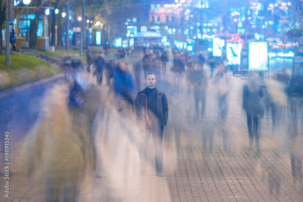 The man stand in the street with a crowd flow. evening night time Stock ...