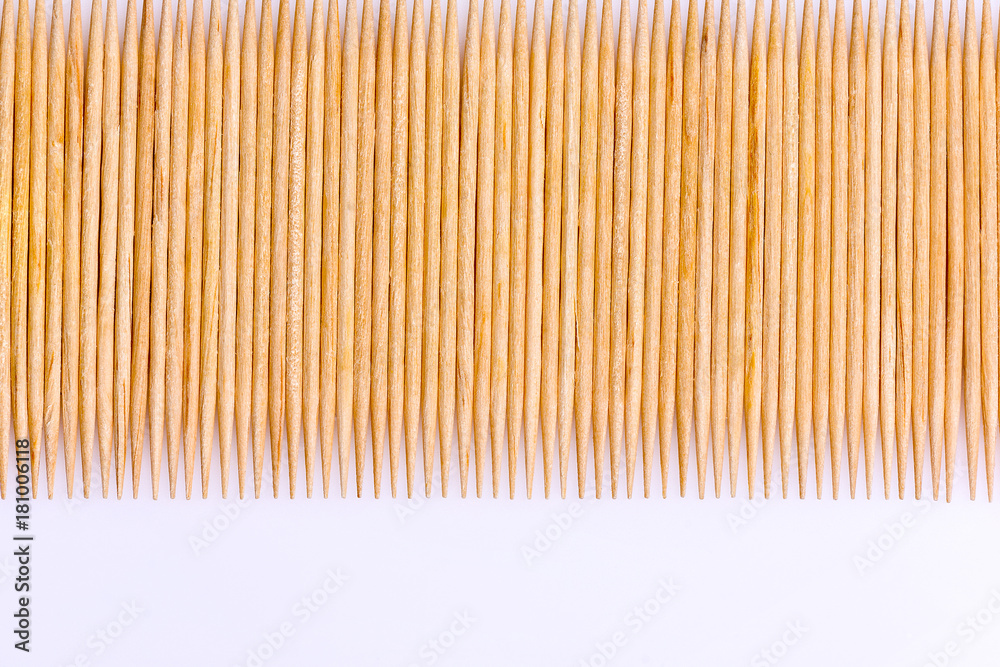 Toothpicks laid in a row horizontally 2/3 of the frame on a white ...