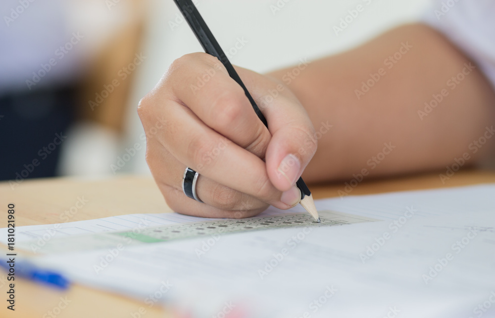 Students holding pen in hands taking exams, writing examination room ...