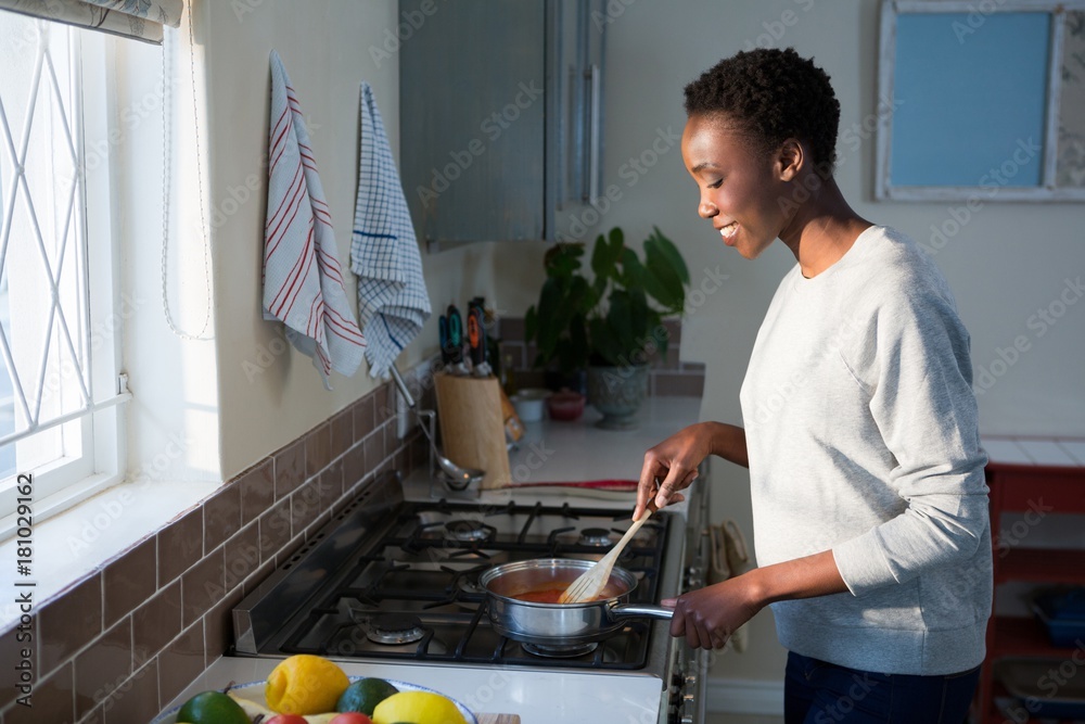 Beautiful woman cooking food in kitchen Stock Photo | Adobe Stock