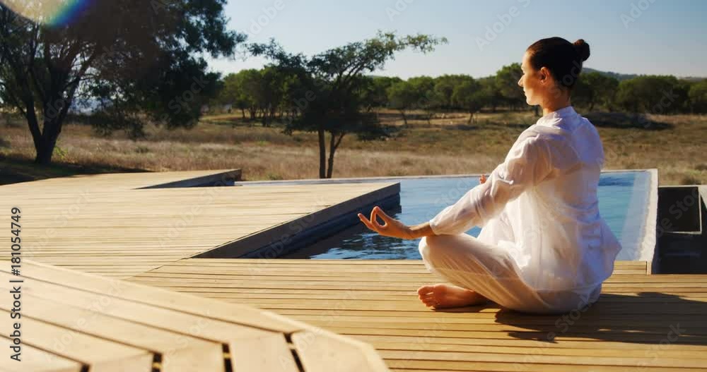 Woman performing yoga near pool side Stock ビデオ | Adobe Stock