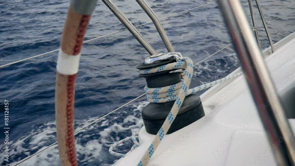 Closeup on left sailing boats winch looking through steering wheel ...