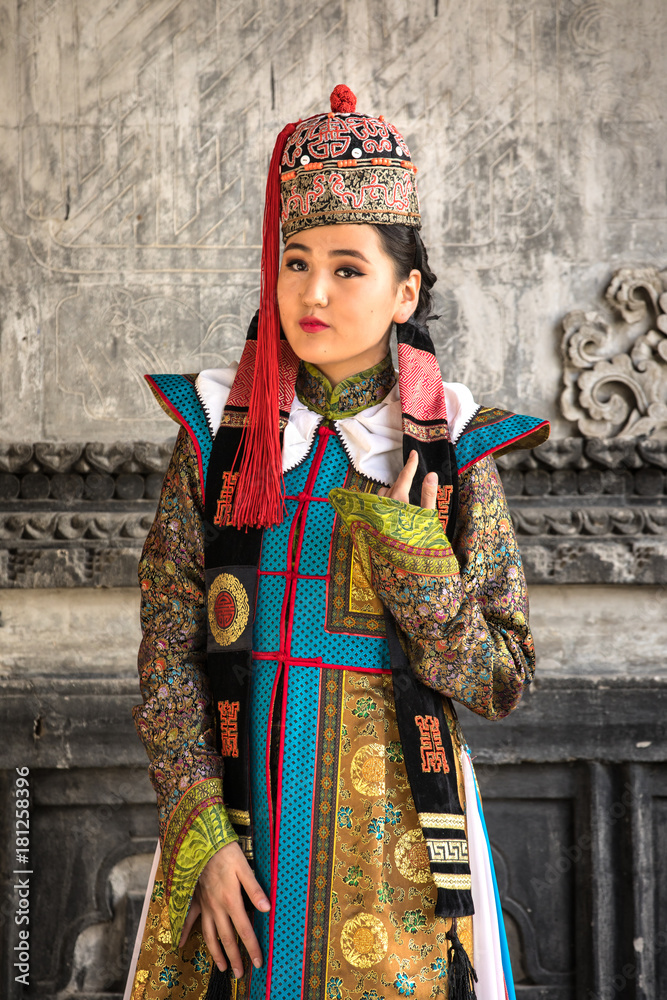 Young Mongolian woman in a traditional 13th century costume in a temple ...