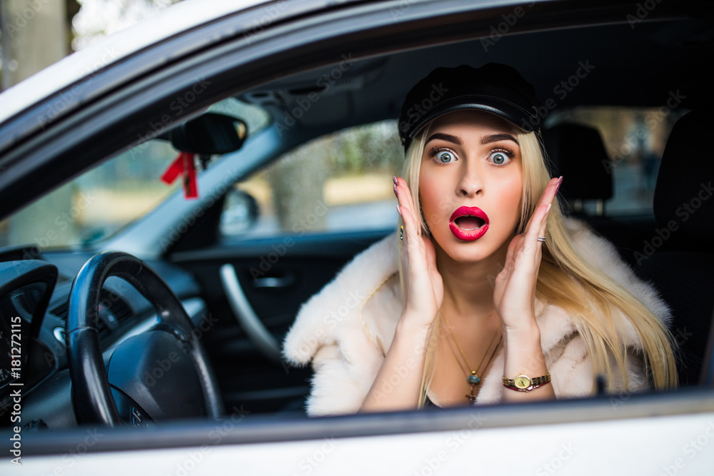 Distracted fright face of a woman driving car, wide open mouth eyes ...