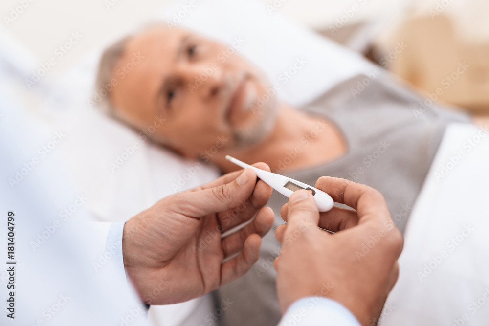 The old man lies on a cot in the medical ward. Next to him is a doctor ...