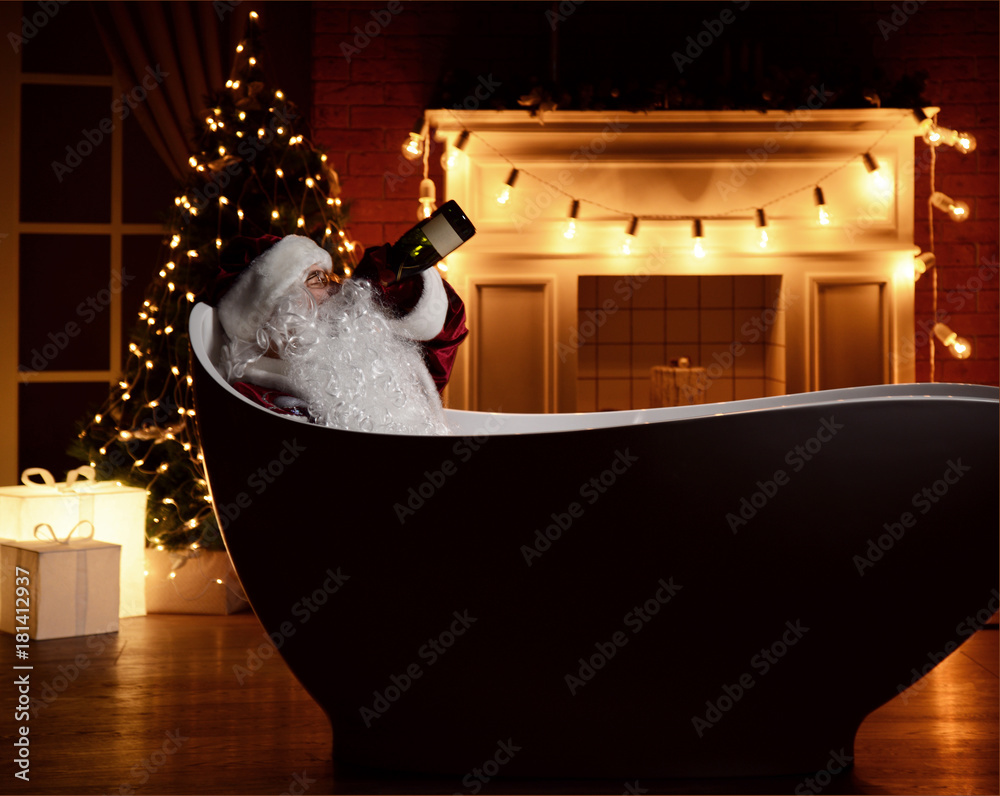 Bad Santa Claus lying in bathtub over christmas tree interior ...