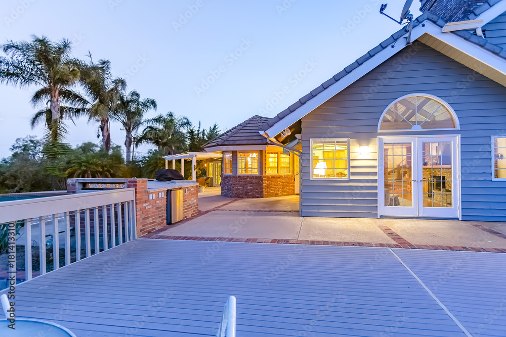 Large blue house with large deckfrom the backyard at twilight Stock ...