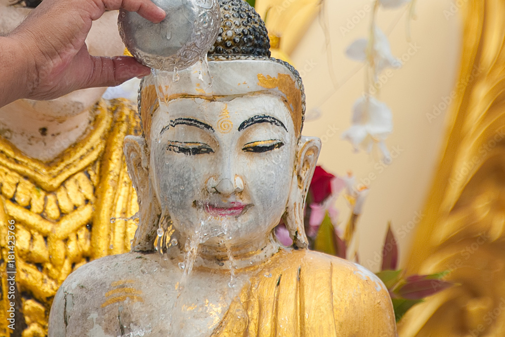 BATHING BUDDHA STATUE FOR BLESSING – A RELIGIOUS RITUAL. Pouring water ...