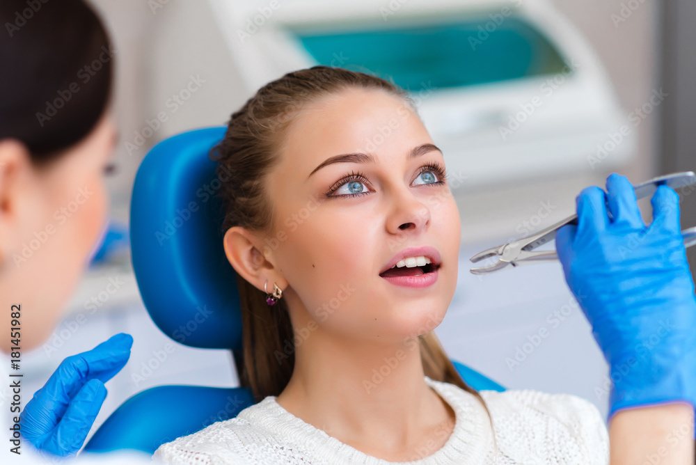 Tooth extraction beautiful girl in dentistry. Stock Photo | Adobe Stock