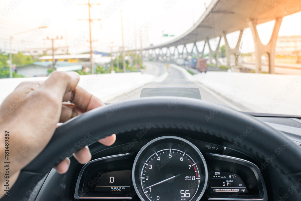 Car dashboard with steering wheel on blurry street background. Using ...