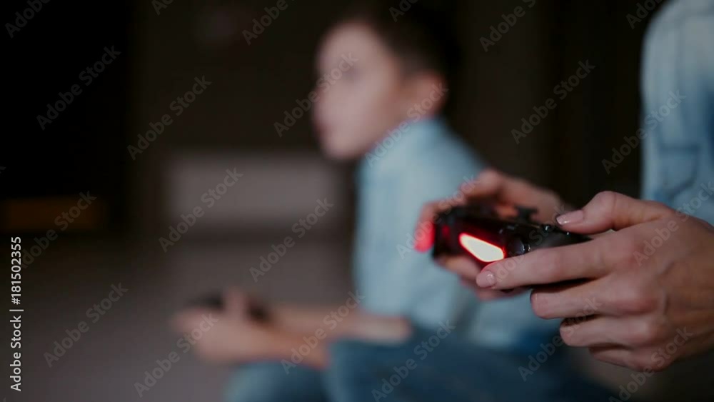 Hands holding a controller to a game console, and in the background the ...