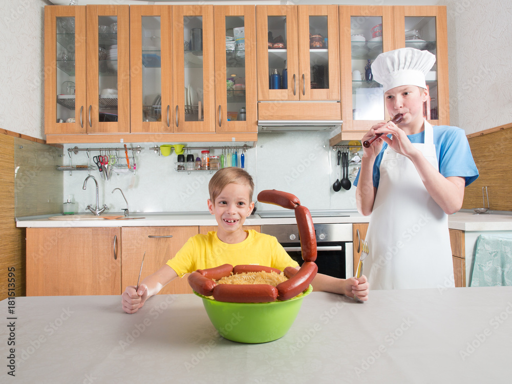 Young boy in the form of a chef with an apron and a cap smiles and ...
