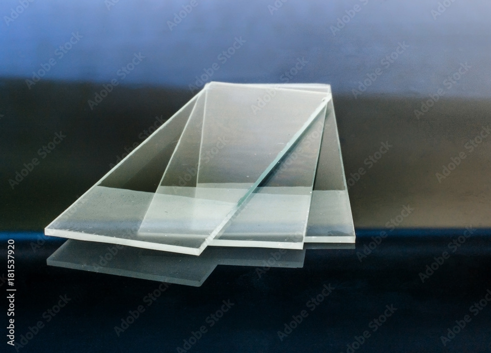 Organized microscope glass slides on top of a reflective glass surface ...