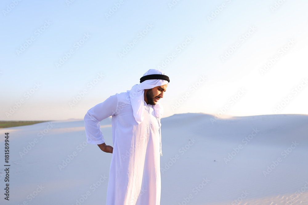 Handsome Arab sheik suffers from discomfort in back, standing in Stock ...