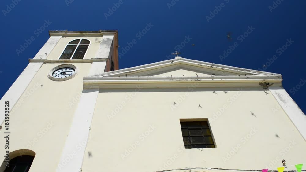 facciata di una chiesa con il suo canpanile e stormo di rondini su ...