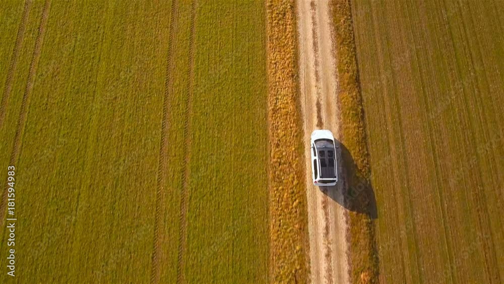 White minivan car driving beside farm fields top view drone shot 4K ...