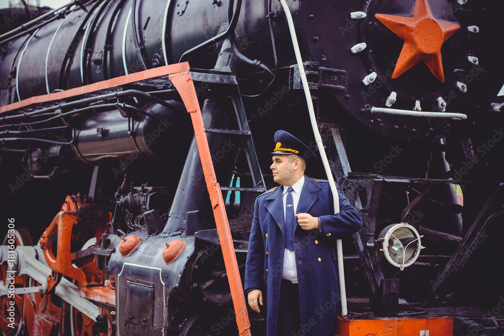 European or American train conductor is on his duty on a platform and ...