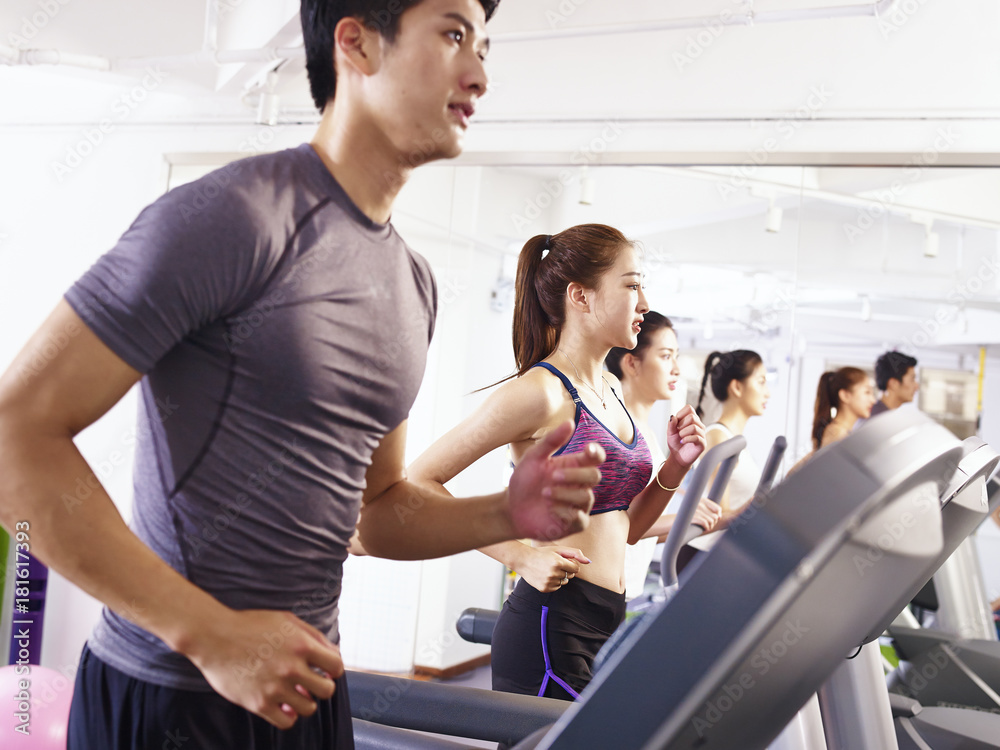asian young people working out on treadmill Stock 写真 | Adobe Stock