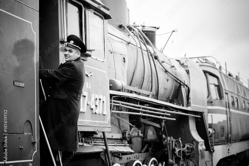 European or American train conductor is on his duty on a platform and ...