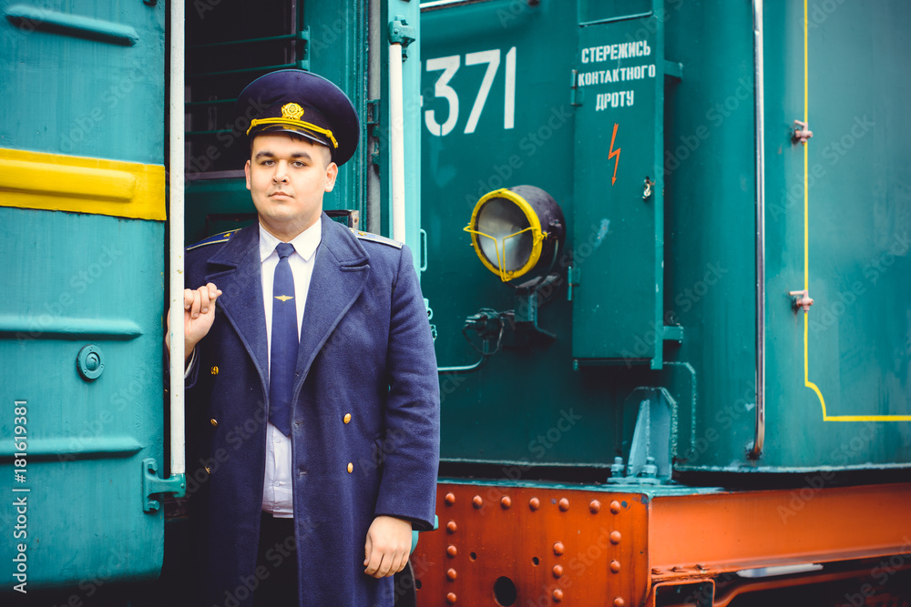 European or American train conductor is on his duty on a platform and ...