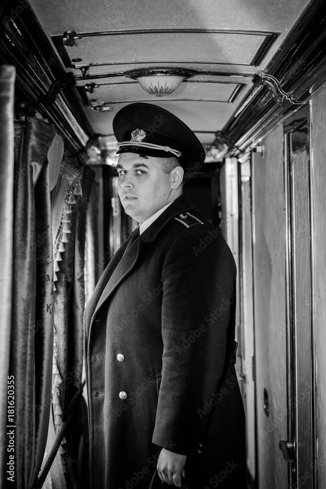 European or American train conductor is on his duty on a platform and ...