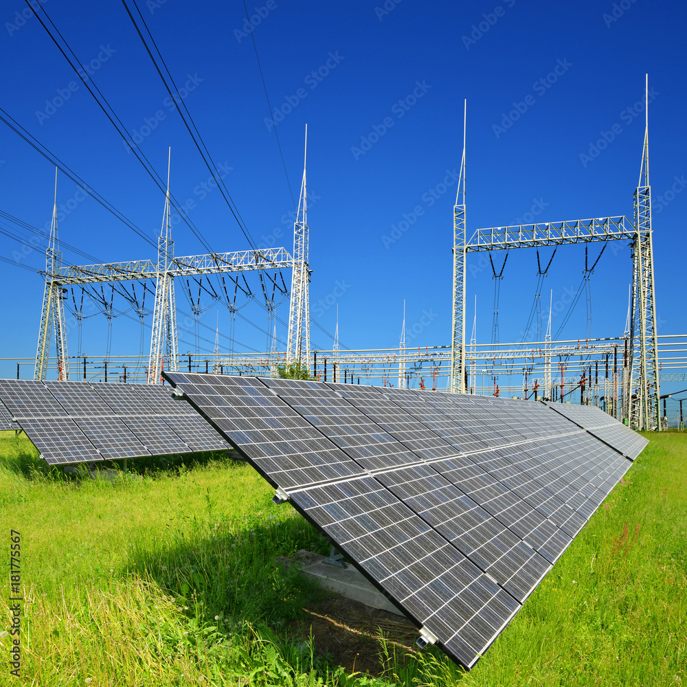 Solar energy panels in the background high voltage power substation ...