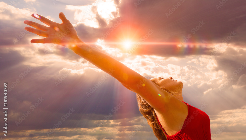 Mujer con brazos abbiertos al cielo y puesta de sol.Concepto de ...