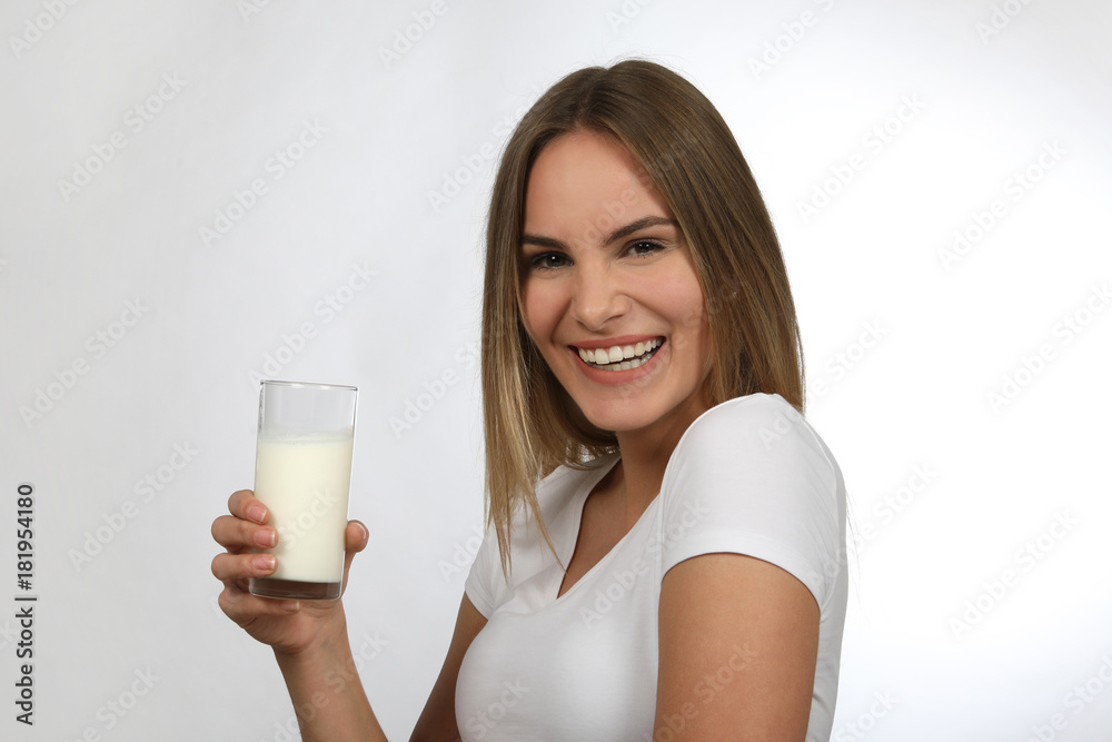 Hübsche blonde Frau mit einem Glas Milch lacht Stock-Foto | Adobe Stock