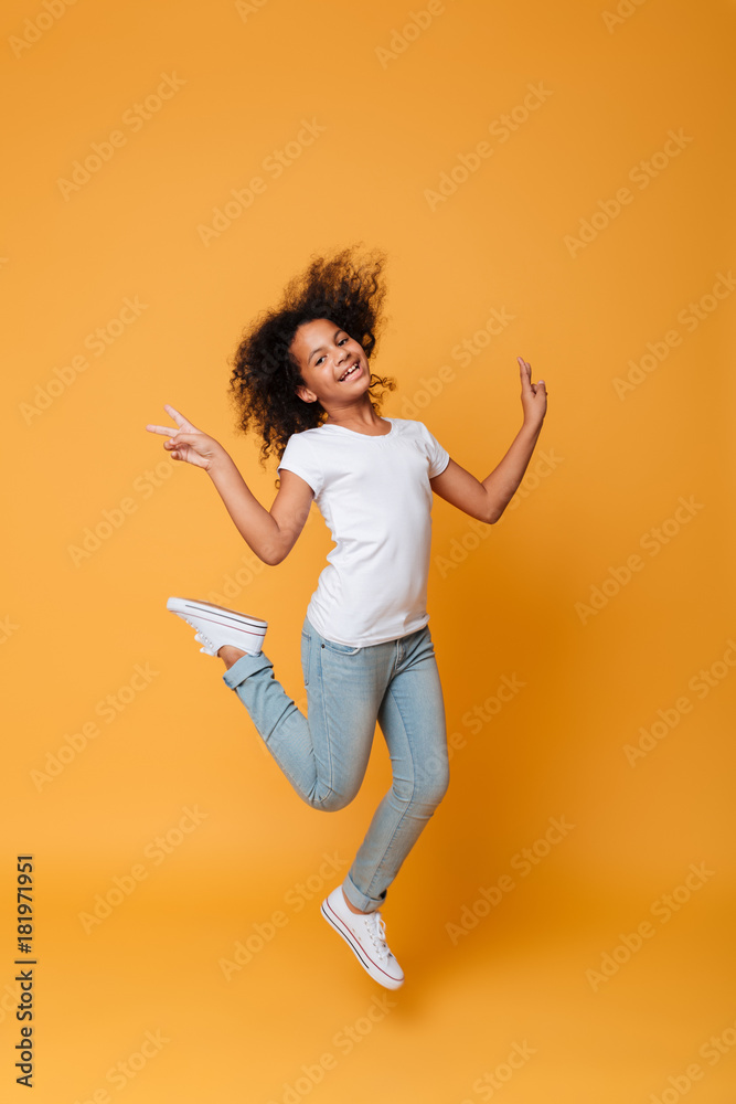 Full length portrait of a smiling little african girl jumping Stock ...
