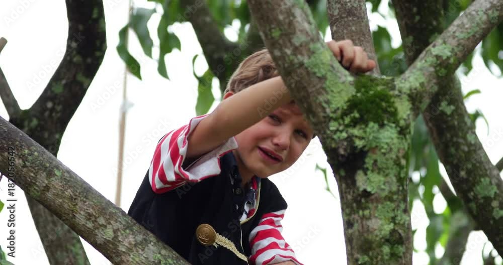 Young boy on top of a tree cries, sobs, and is tearful. Candid ...