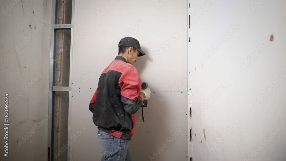 Construction worker is installing a new drywall in the apartment ...