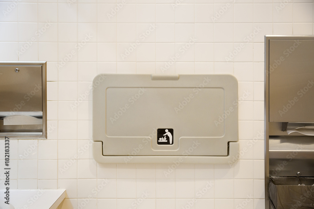 Baby diaper table in a public restroom. Child changing board in a ...