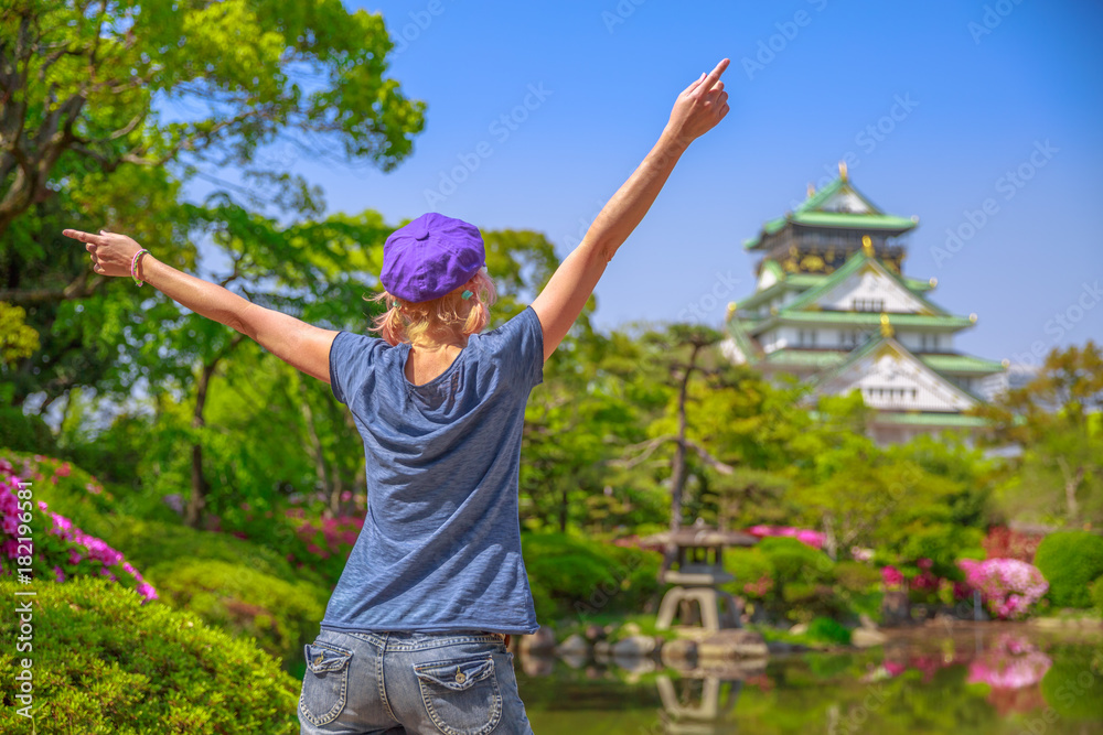 Happy tourist enjoys in front of Osaka Castle surrounded by spring ...